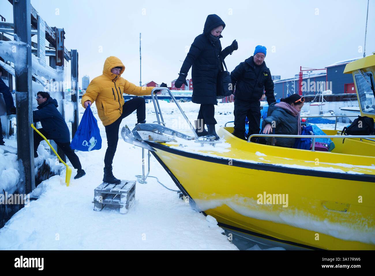 People board on a boat before departure in the harbour of Nuuk ...