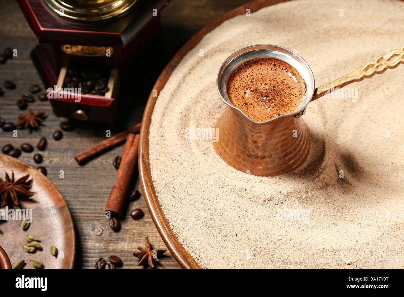 Turkish coffee cooking in sand on wooden background Stock Photo - Alamy