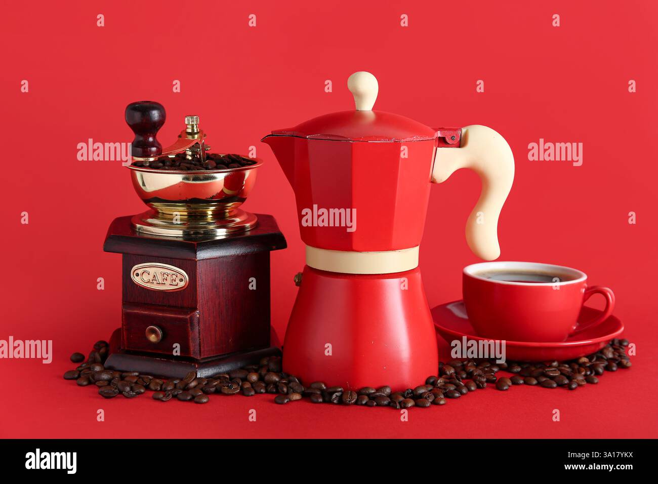 Geyser coffee maker, cup of coffee and grinder among beans on red ...