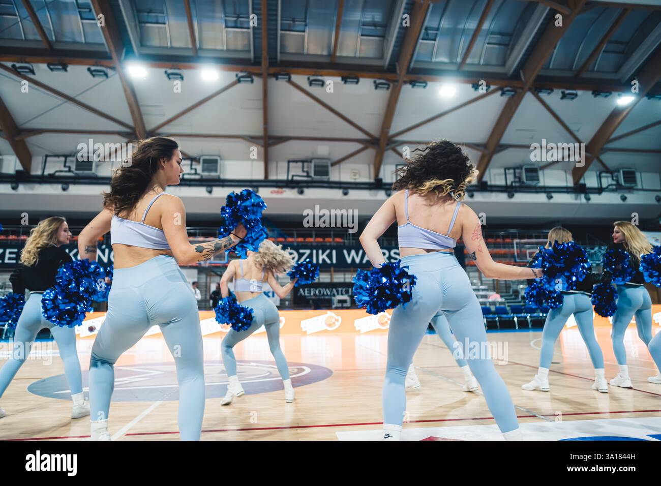 Cheerleaders Performing Dance Routine in Modern Sports Arena with ...