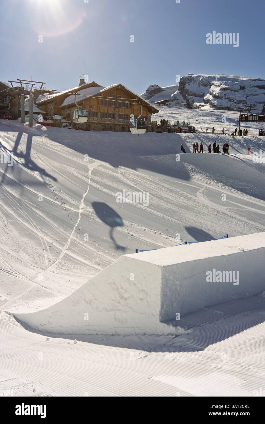 Snow covered jump ramp, kicker in a winter landscape with soft lighting ...