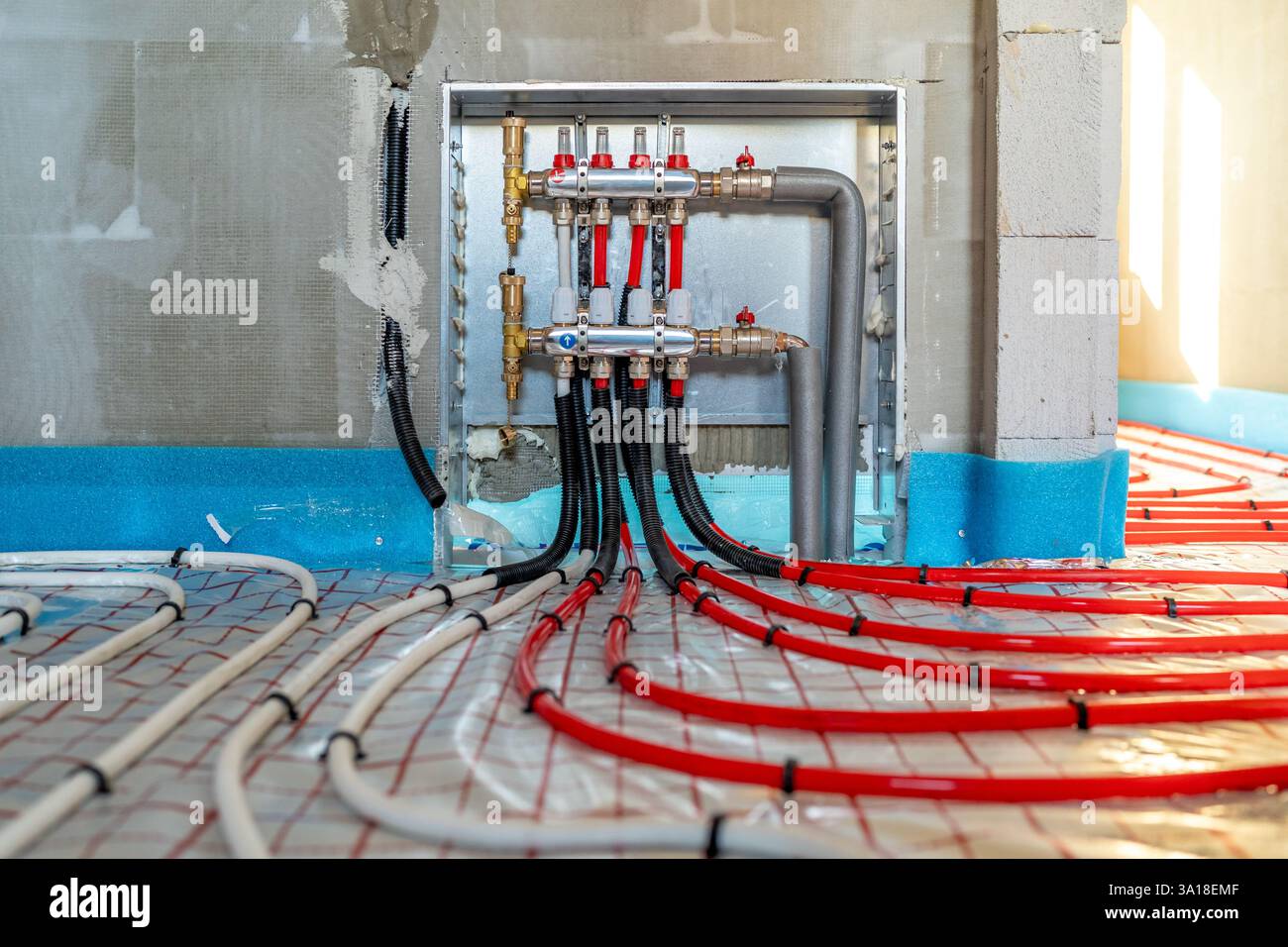 Underfloor heating system manifold with pipes distributing hot water ...