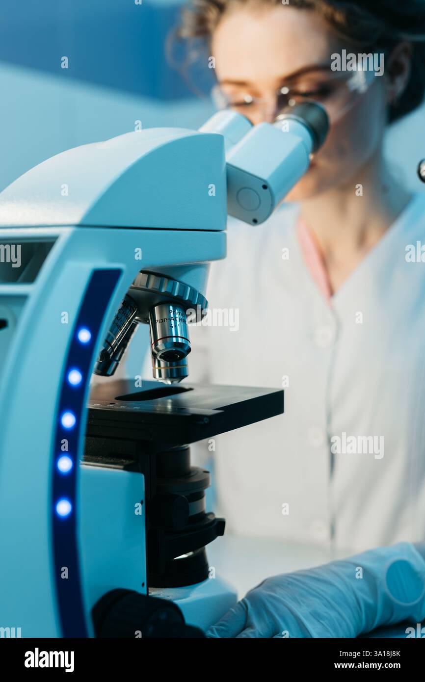 A young female scientist conducts research in a medical lab, using a ...