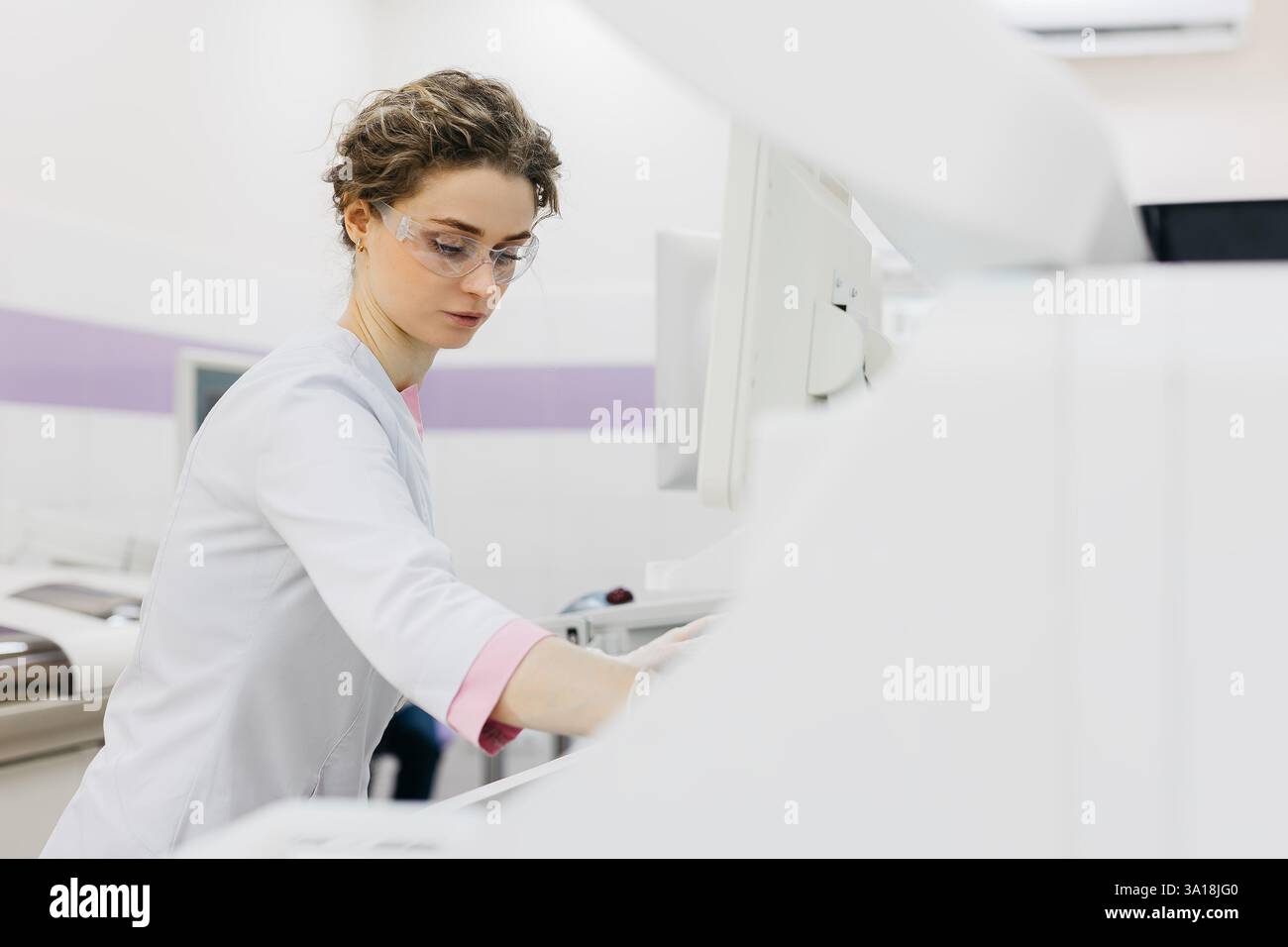 A young female lab technician against the backdrop of modern laboratory ...