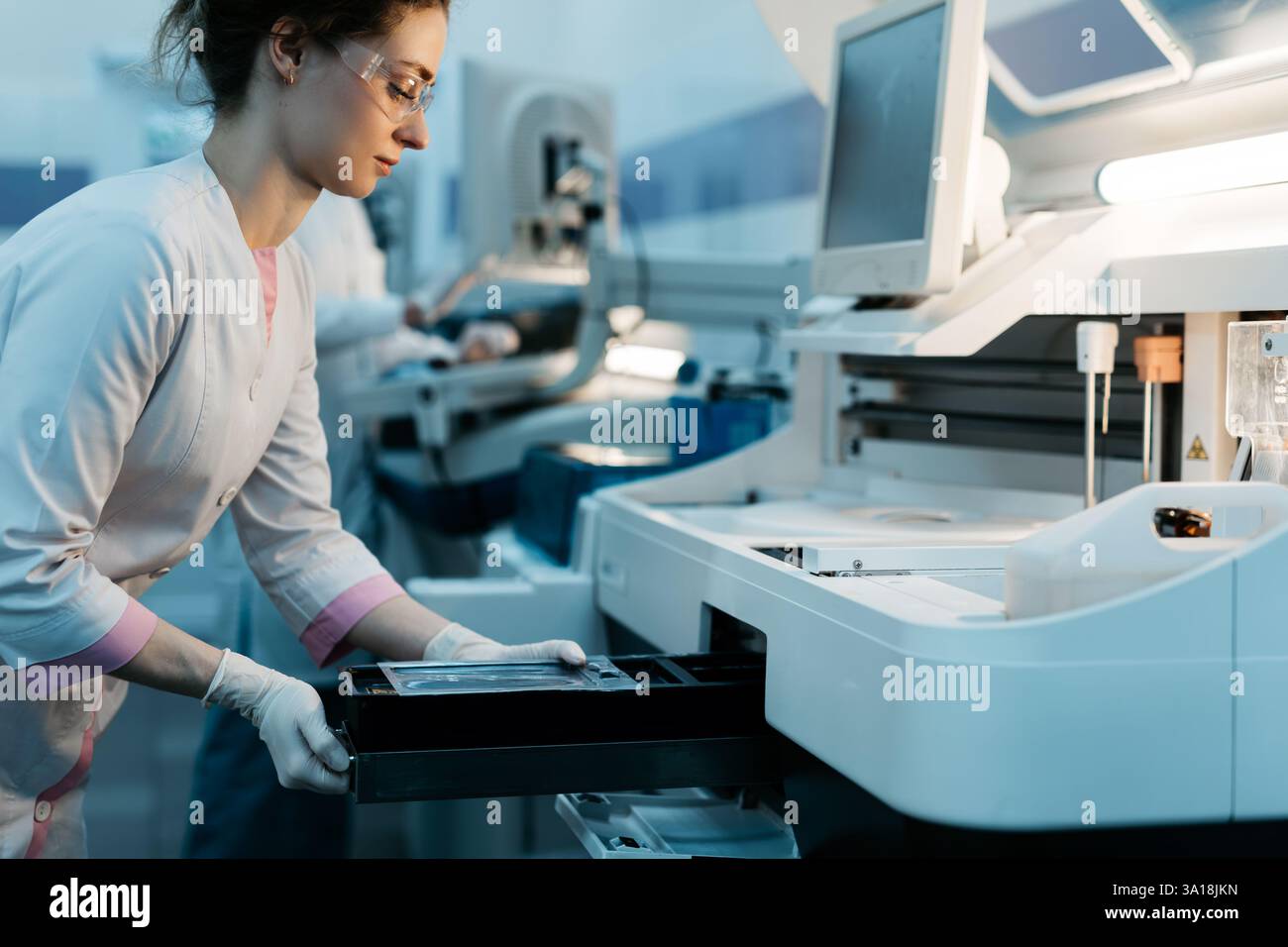 A young woman works in a modern laboratory with advanced equipment and ...