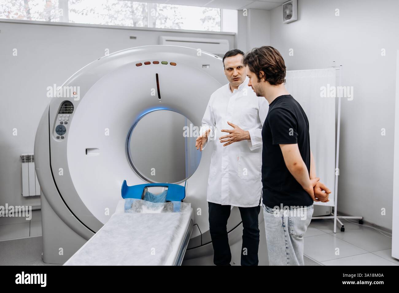 A dedicated doctor completes an MRI examination while engaging with a ...
