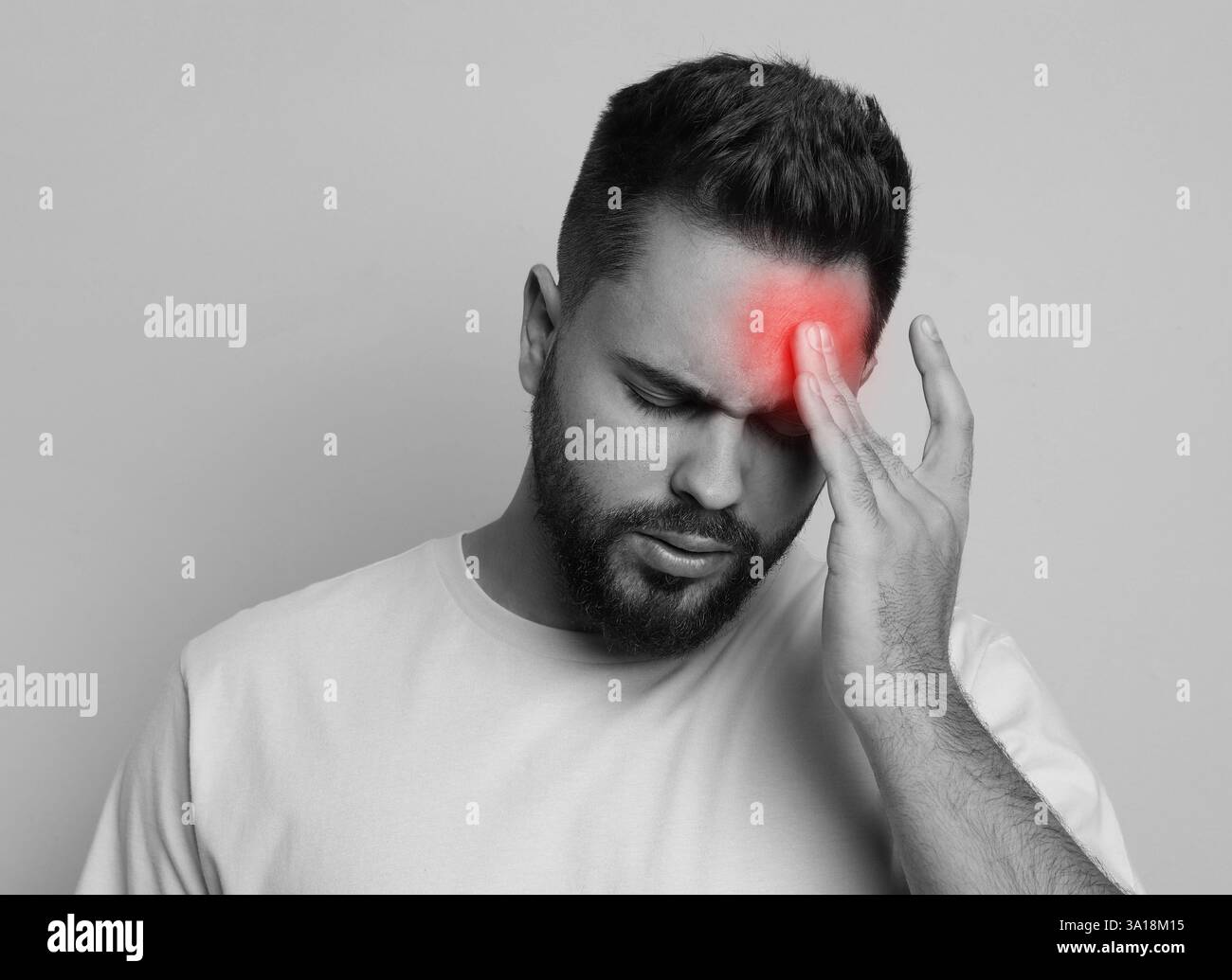 Man suffering from headache on light background. Black and white effect ...
