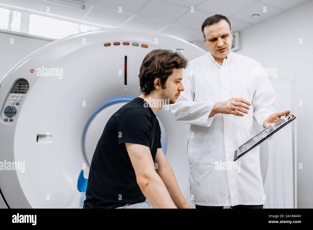 A dedicated doctor completes an MRI examination while engaging with a ...