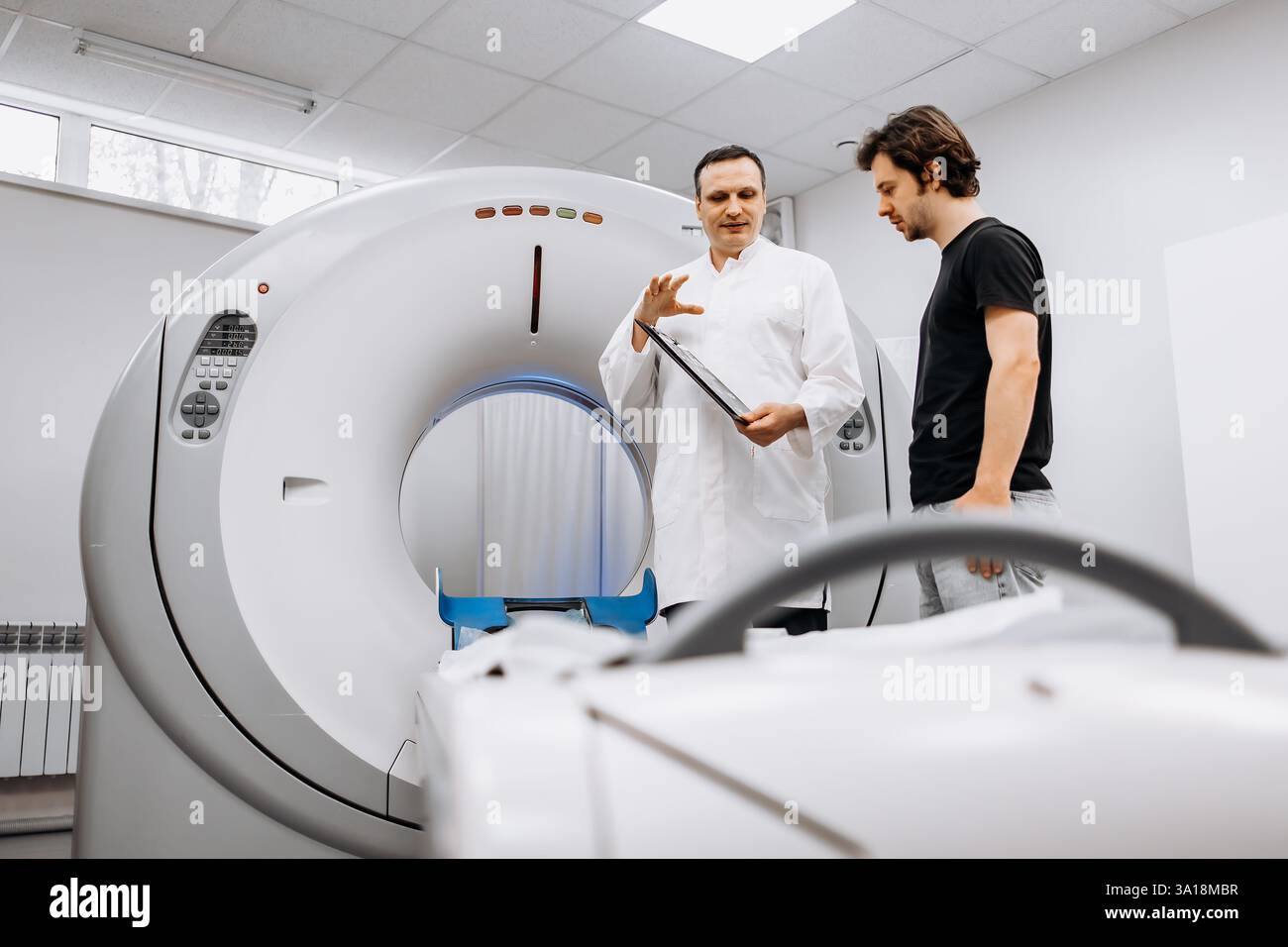A dedicated doctor completes an MRI examination while engaging with a ...