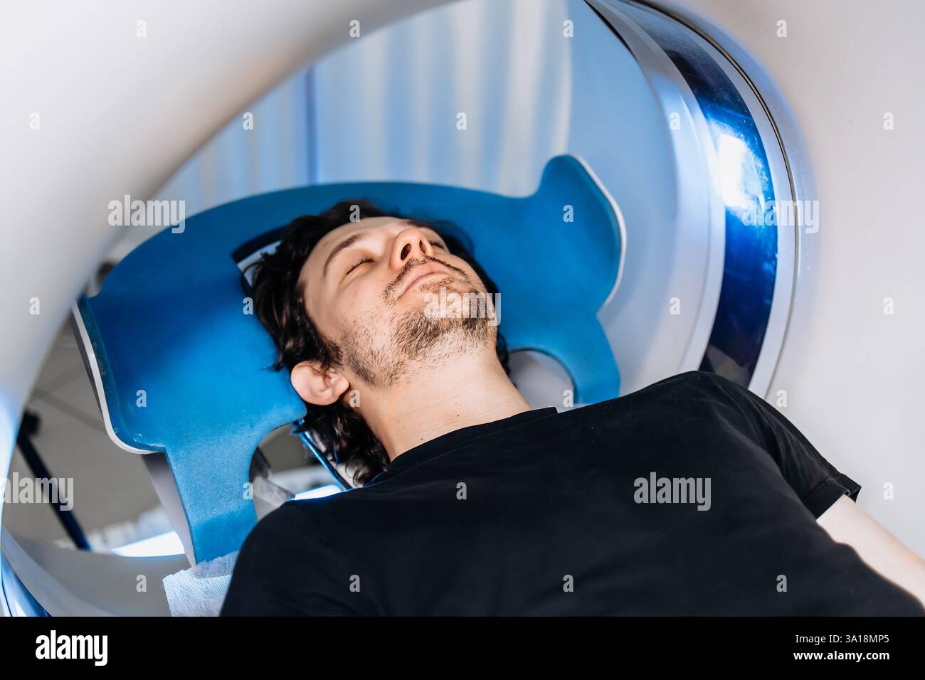 The patient lies inside an MRI or CT machine where the scan is performed. This high-tech ...
