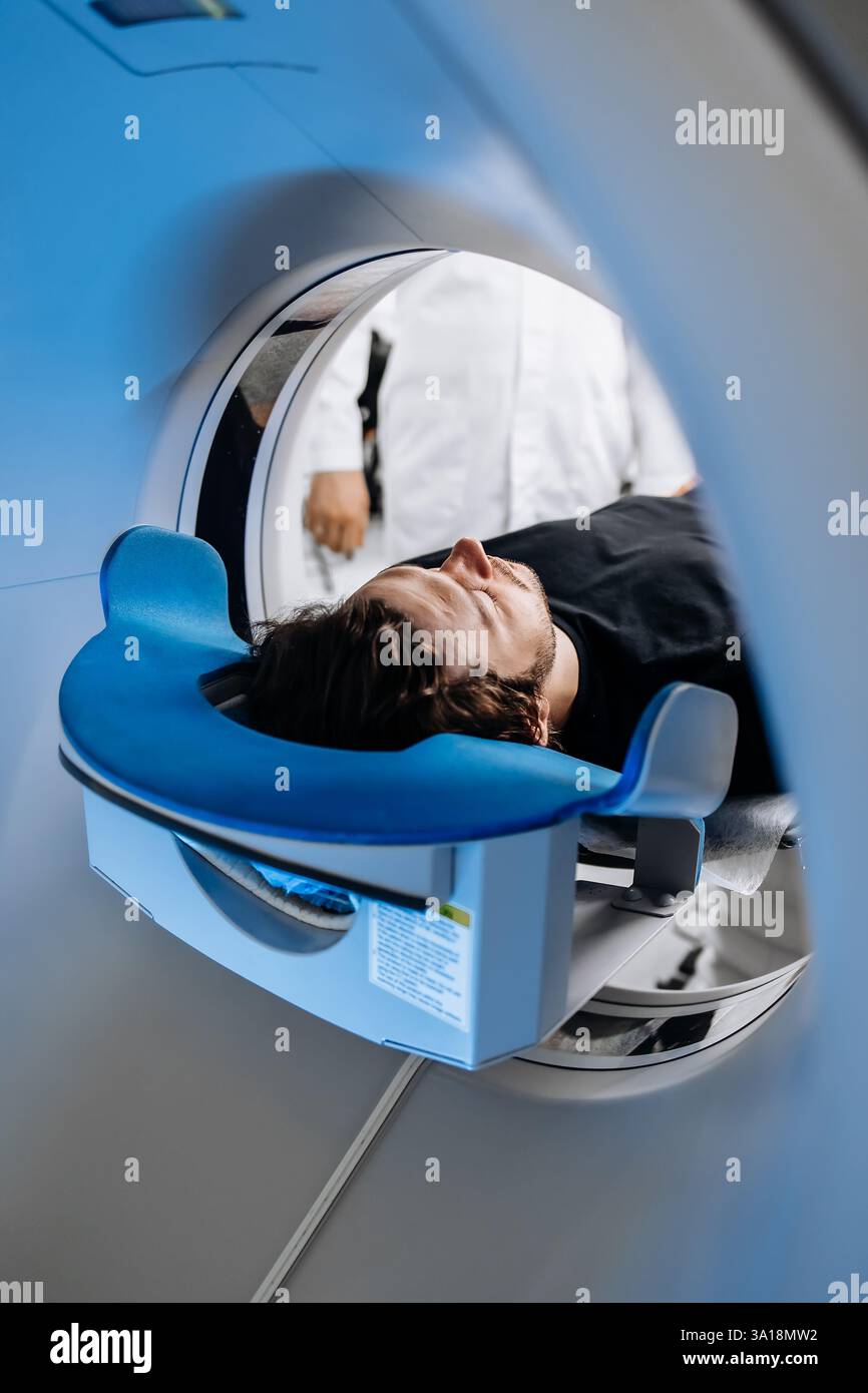 The patient lies inside an MRI or CT machine where the scan is performed. This high-tech ...