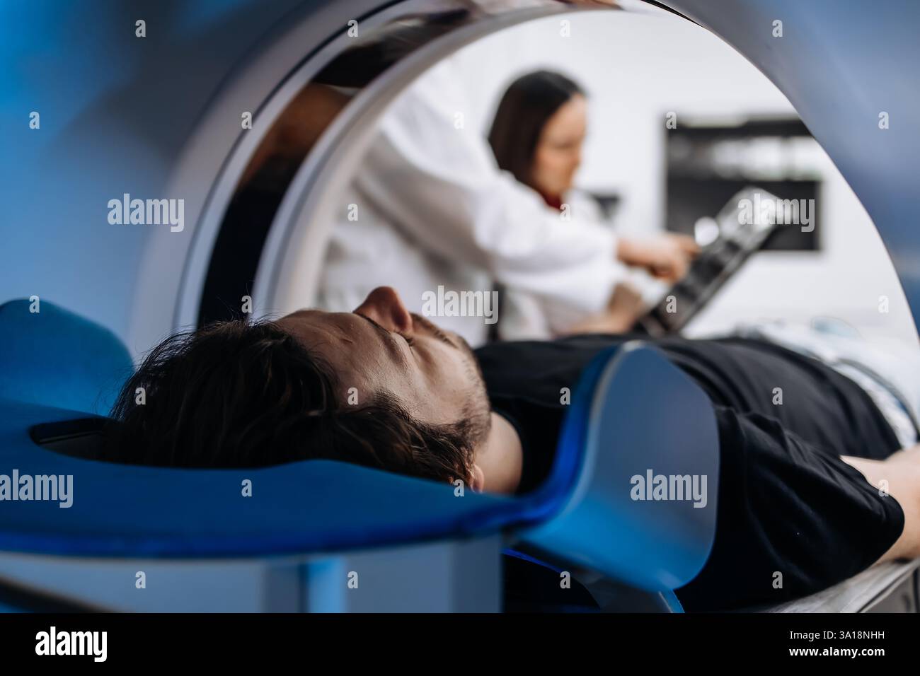 The patient lies inside an MRI or CT machine where the scan is performed. This high-tech ...