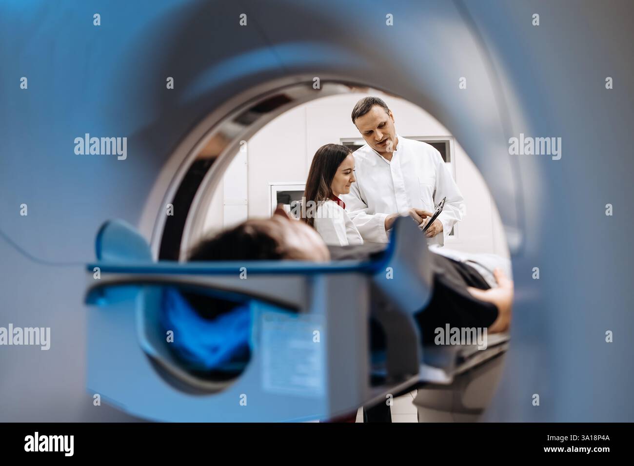 The patient lies inside an MRI or CT machine where the scan is performed. This high-tech ...