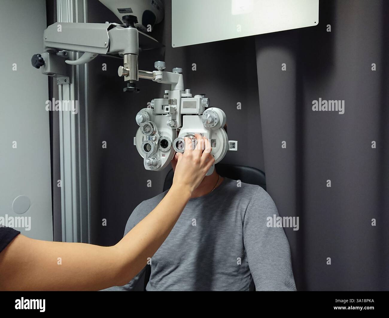 Man in professional clinic wearing phoropter for eye assessment, vision ...