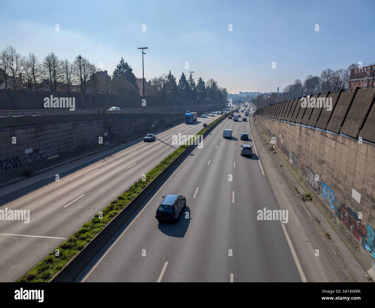 A busy highway with multiple lanes, featuring cars and trucks traveling ...