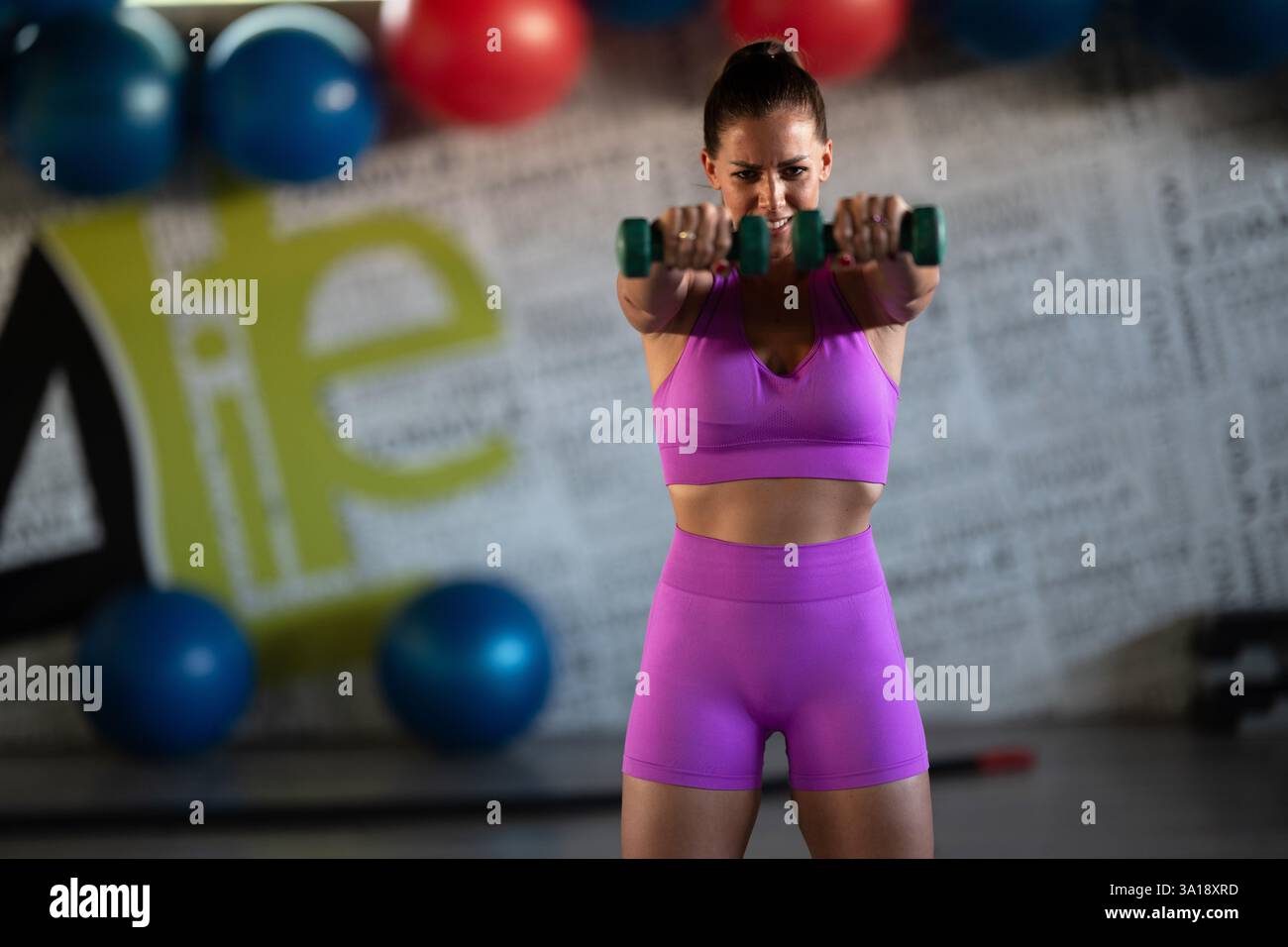 A focused and determined woman performs a strength building dumbbell ...