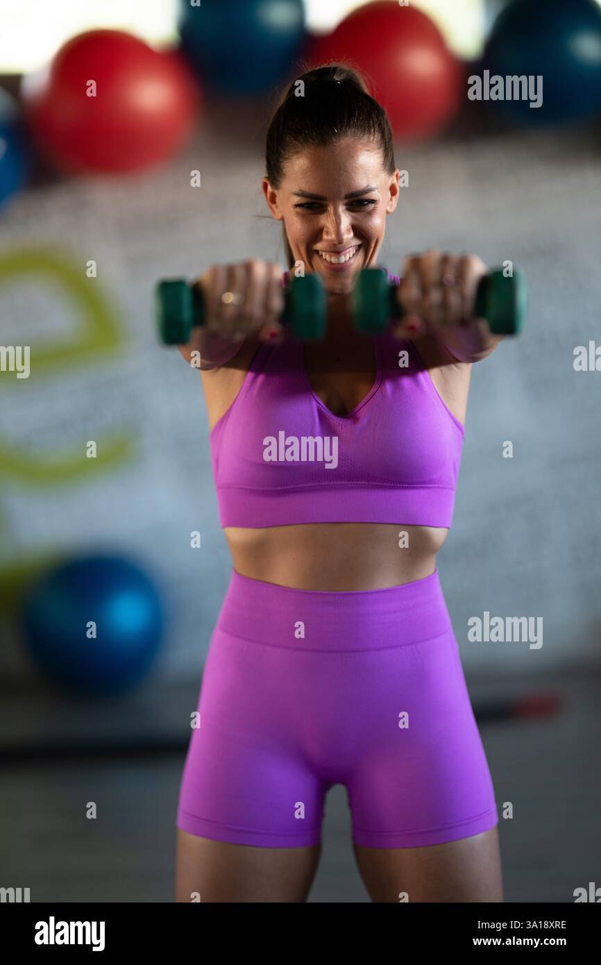 A focused and determined woman performs a strength building dumbbell ...