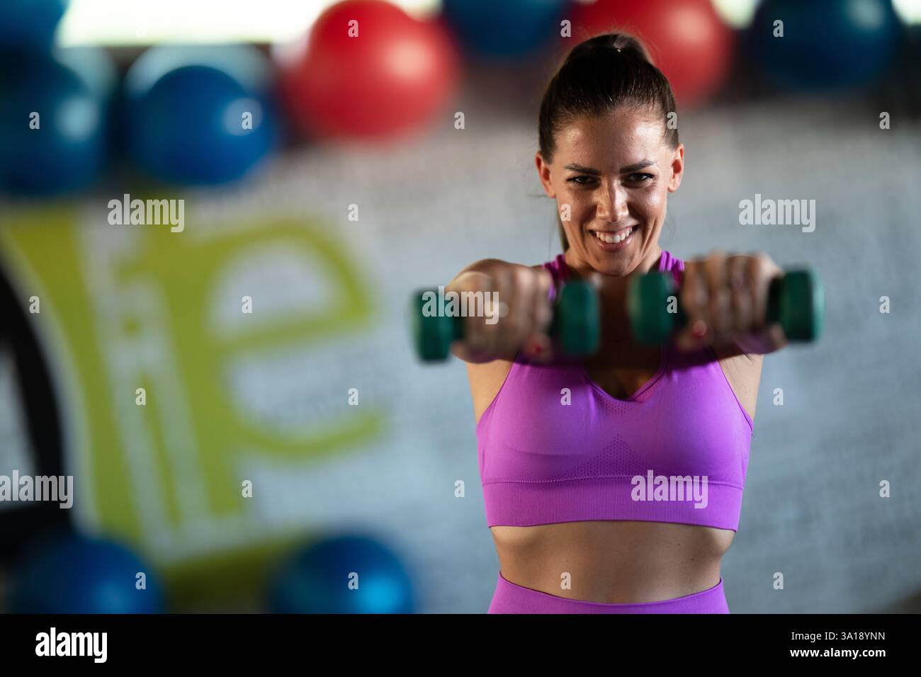 A focused and determined woman performs a strength building dumbbell ...