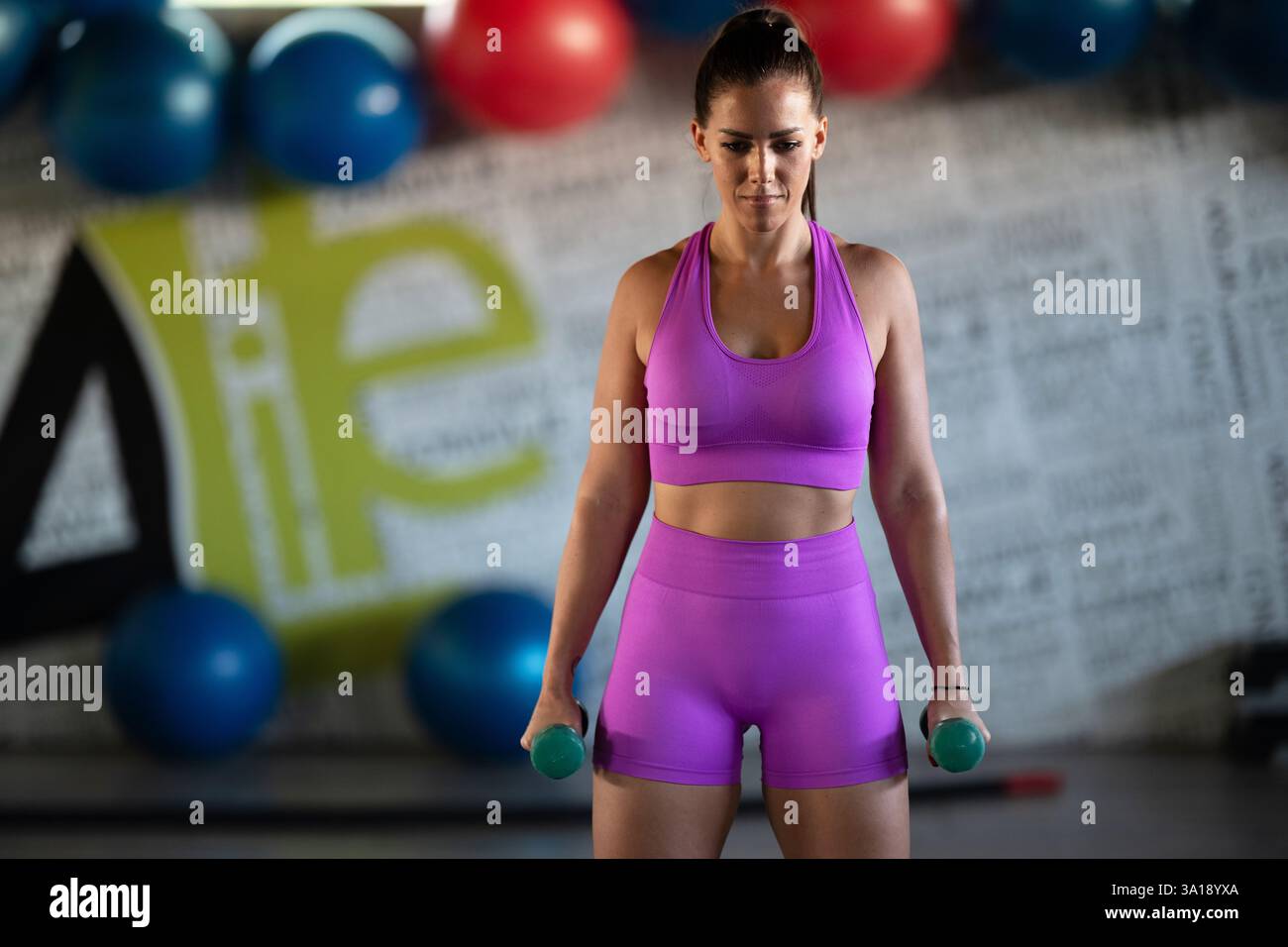 A focused and determined woman performs a strength building dumbbell ...