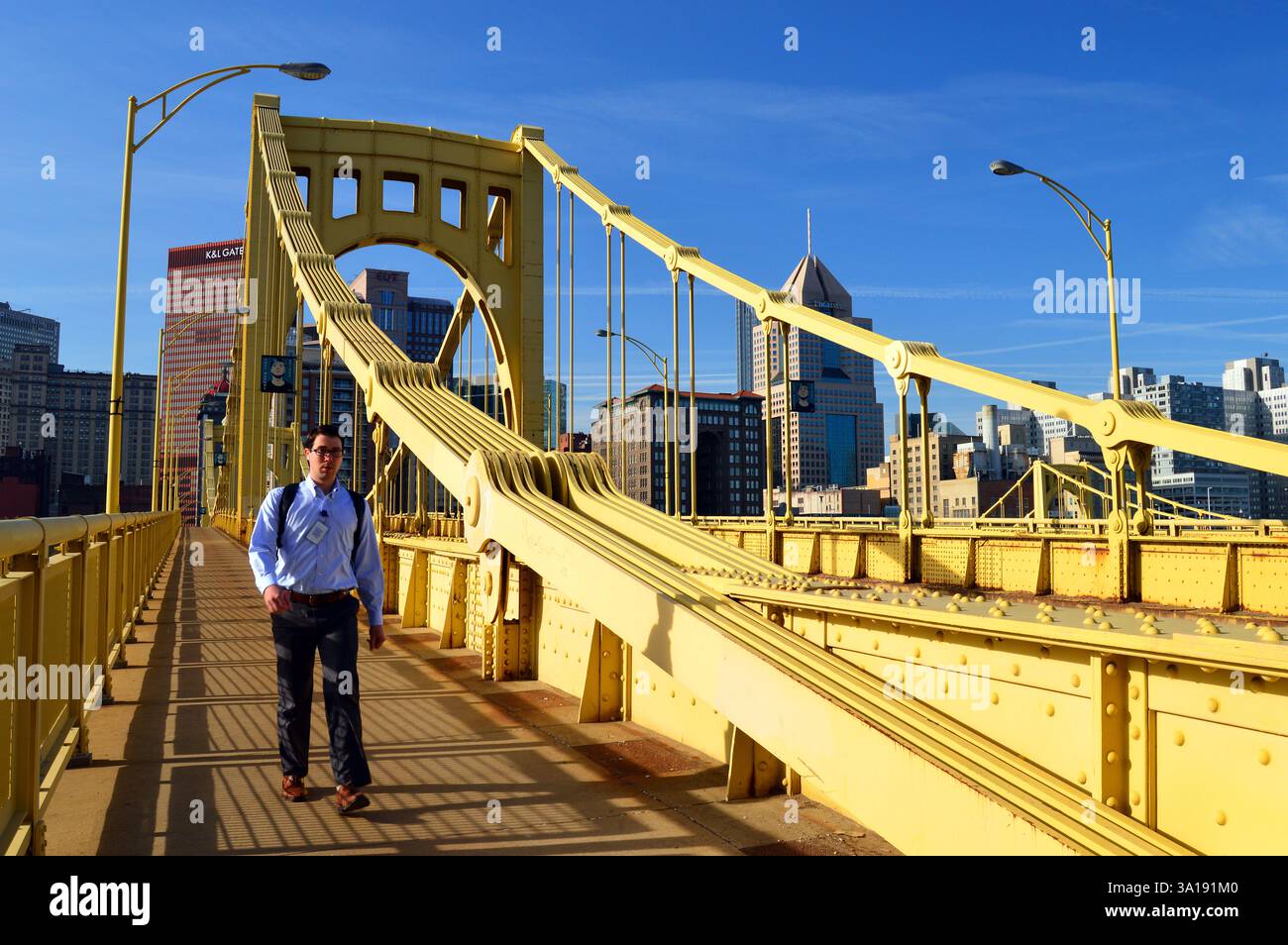A young man walks across the Sixth Street Bridge in Pittsburgh ...