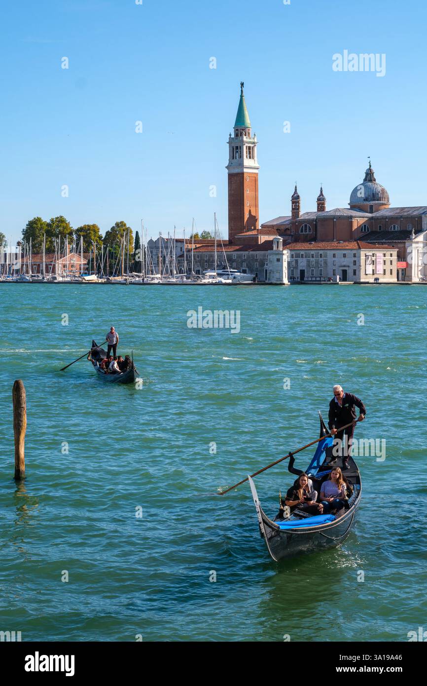 Venice, Italy - 12 October 2024: Gondolas and motorboats navigating the ...
