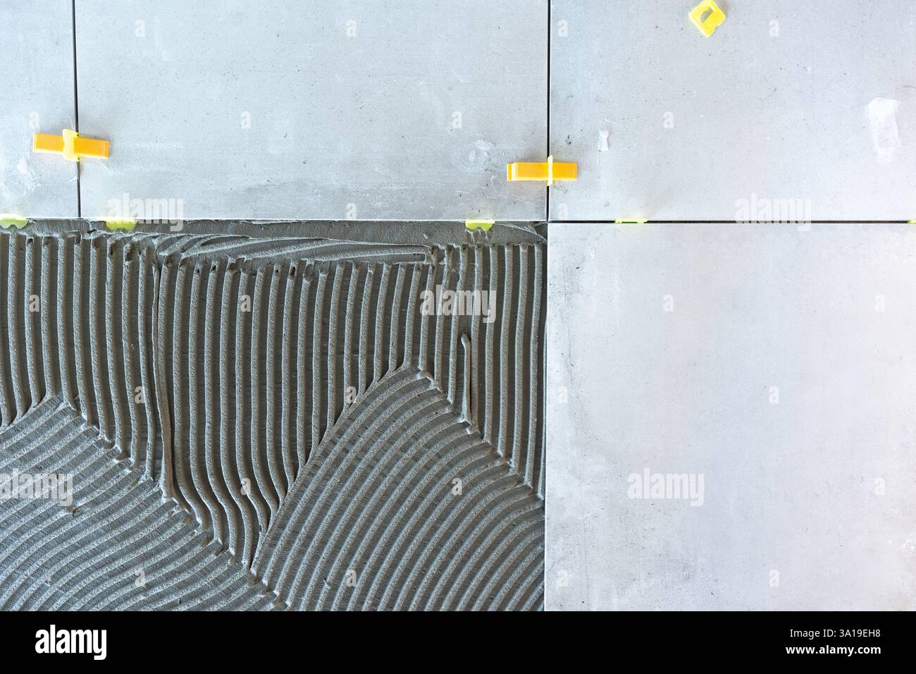 Construction worker installing tile leveling hi-res stock photography ...