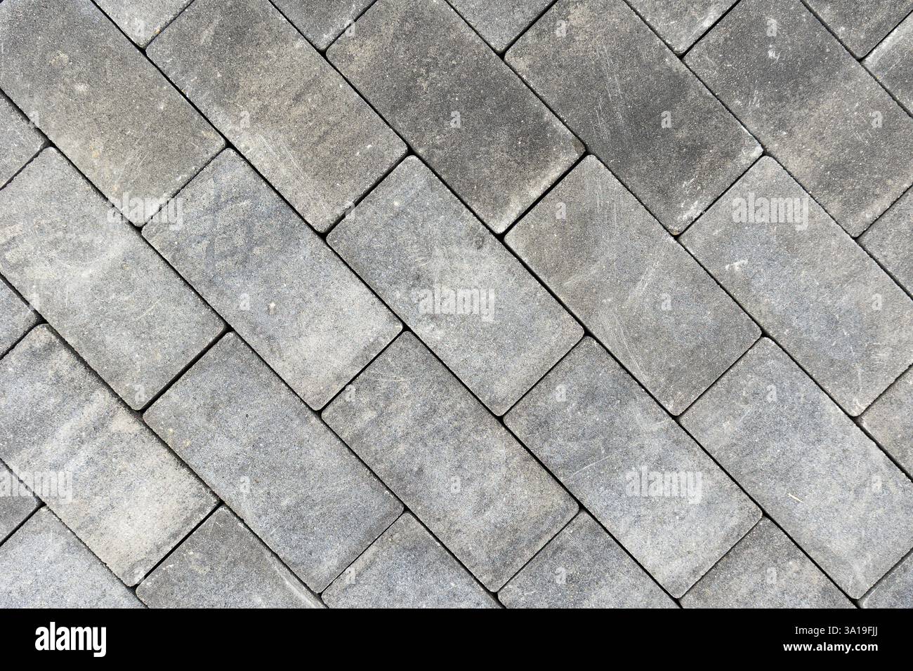 Gray concrete or stone pavers forming herringbone pattern Stock Photo ...