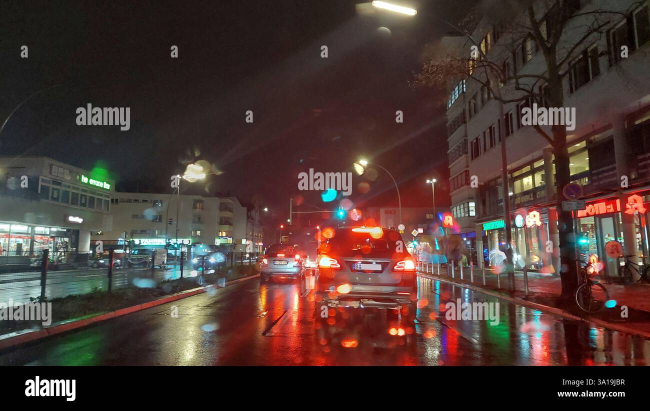 View of city traffic through the windshield in the rain and at night ...