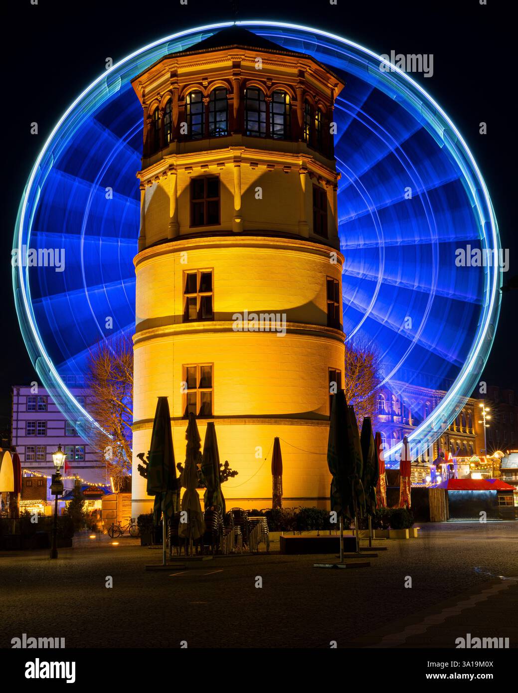 In motion - illuminated giant wheel behind the castle tower of ...