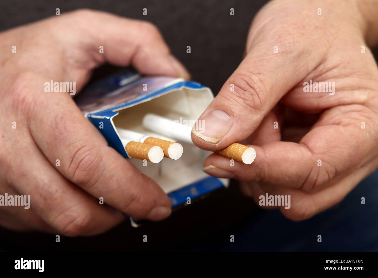 Man holding a pack of cigarettes in his hand Stock Photo - Alamy