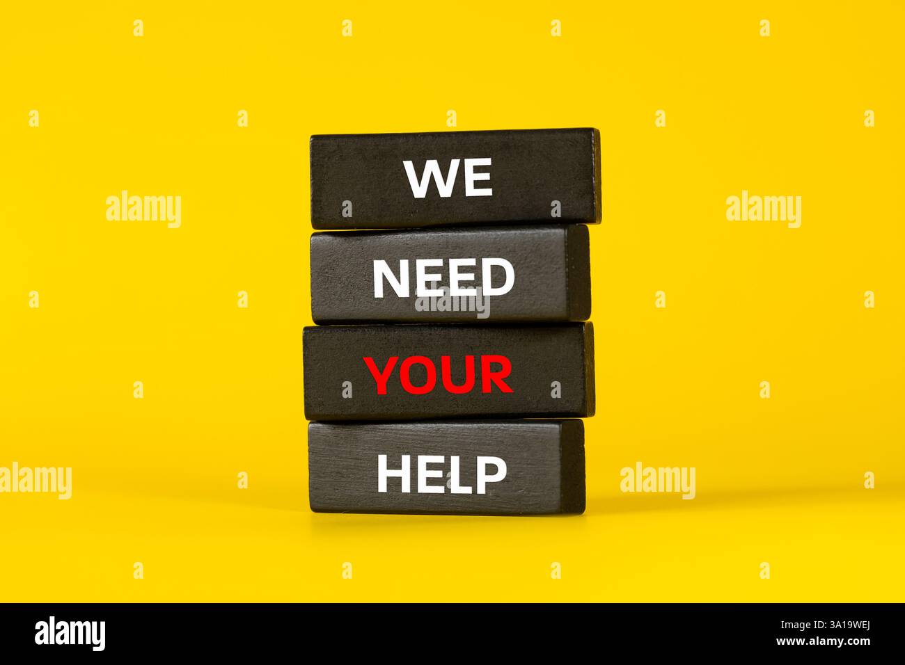 We need your help, Words written on bold black wooden blocks, Yellow ...