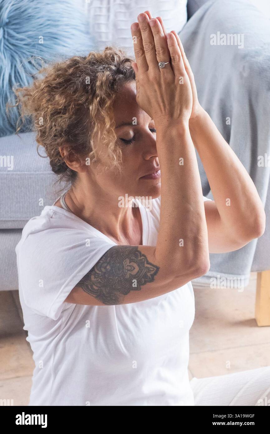 One lady with tattoo doing yoga asana position at hone. Healthy people ...