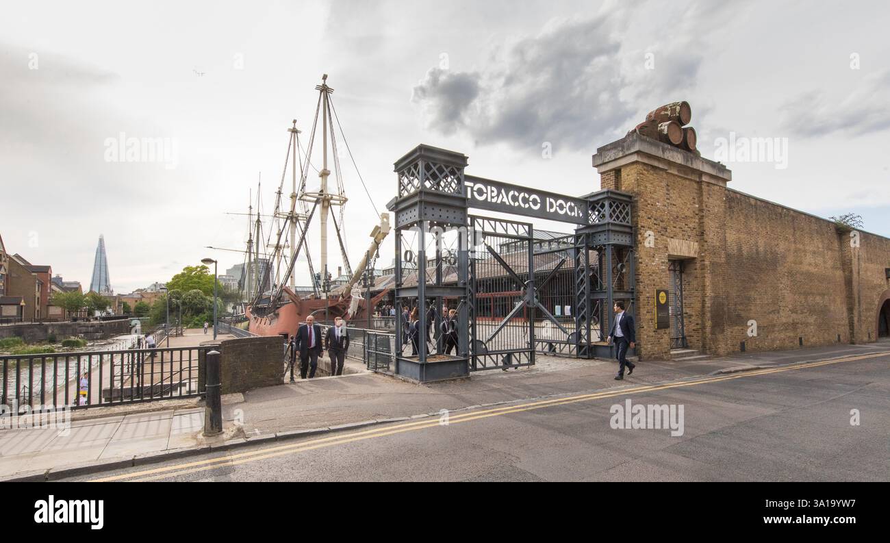 People walk through the gates of Tobacco Dock, London, a historic ...