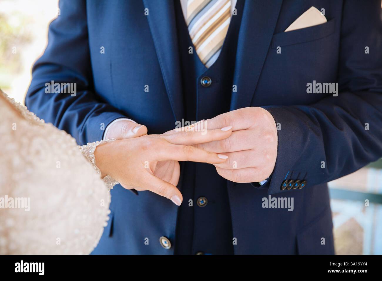 Bride and groom exchange wedding rings in a beautiful outdoor setting ...