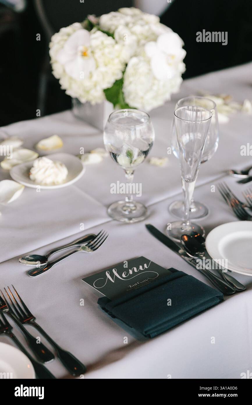 An elegant table with glassware, silverware, and a floral centerpiece ...