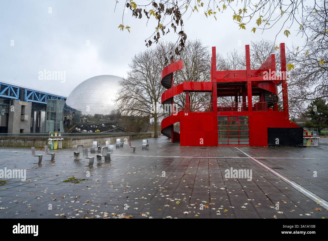 Modern architecture contrasts with nature in a park featuring a red ...
