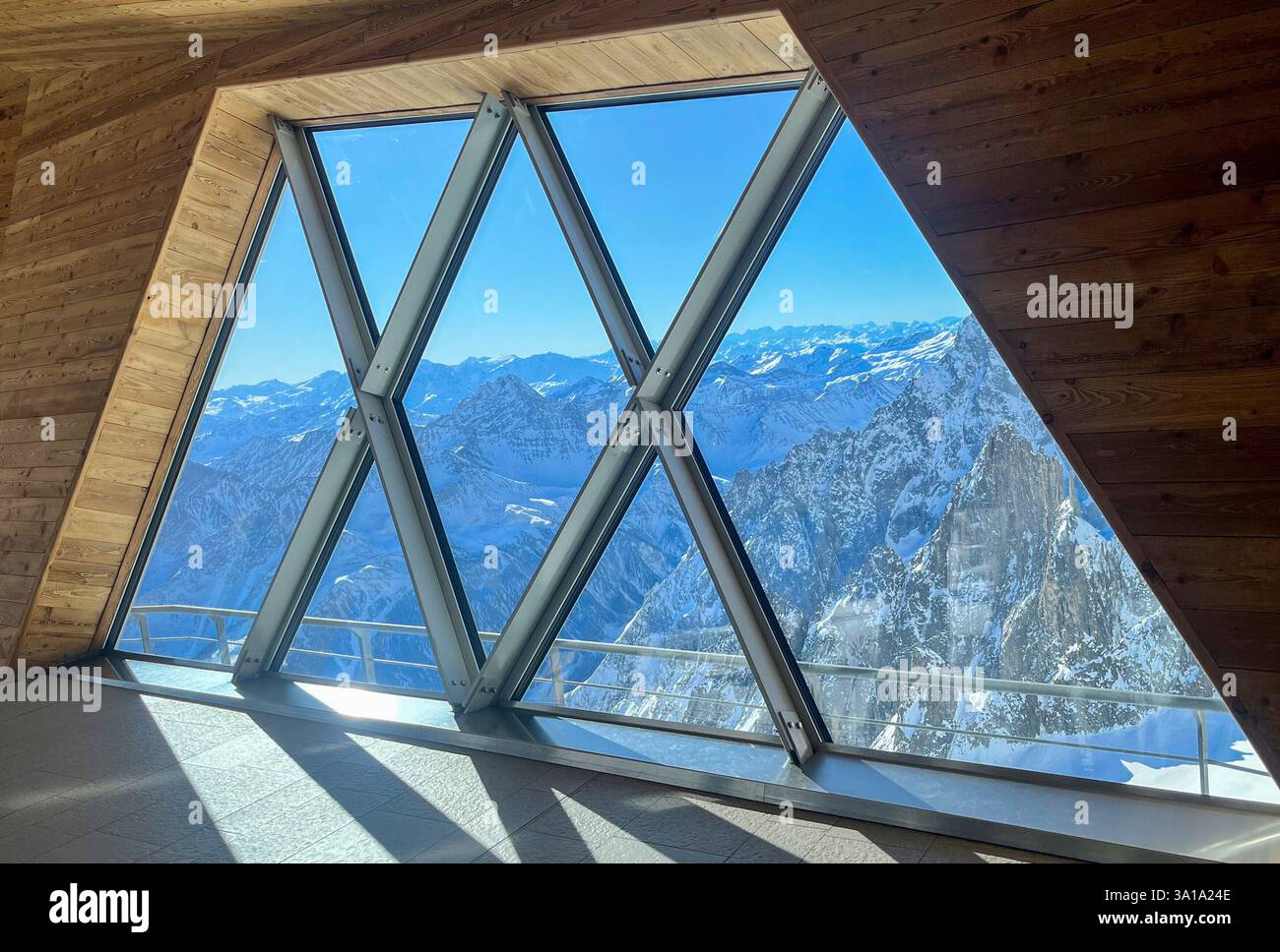 Large windows offering a stunning panorama of snow capped peaks and ...
