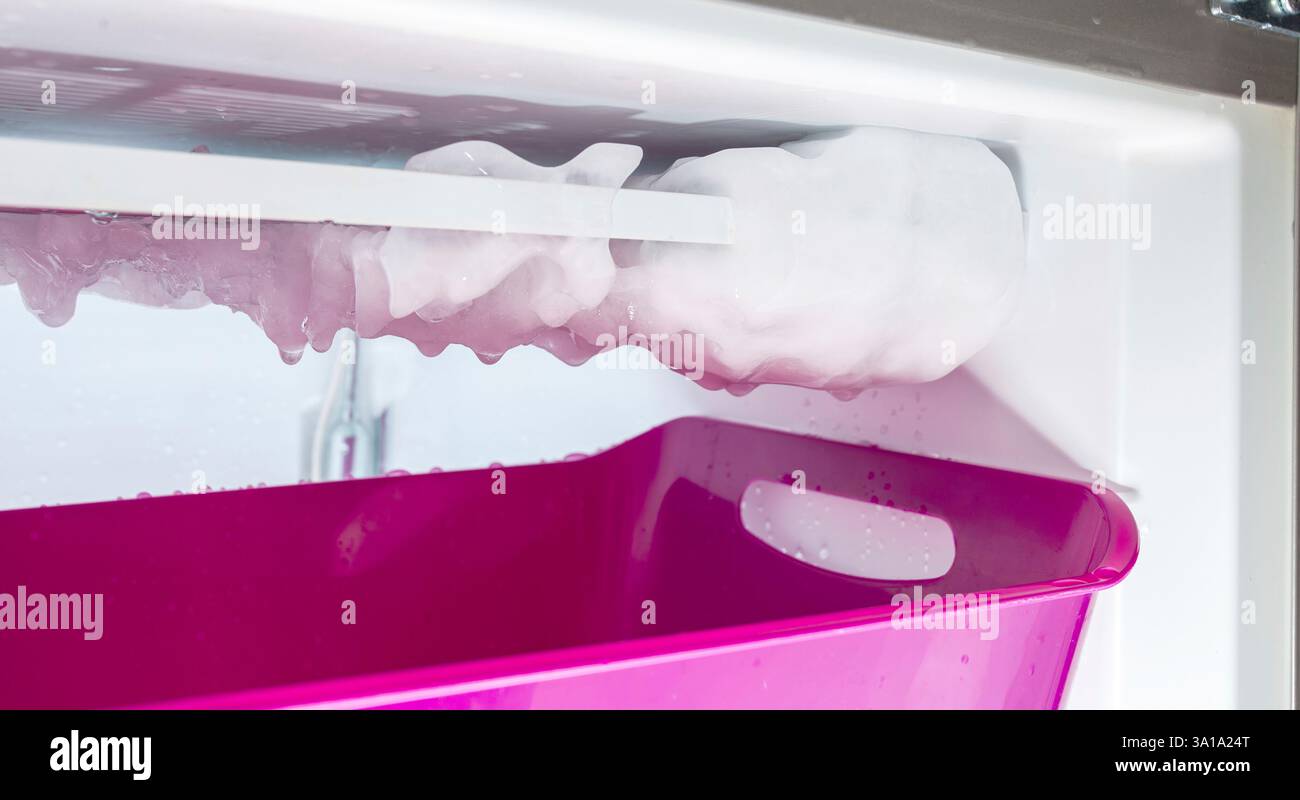Process of defrosting ice in a home freezer. Collecting water in a ...