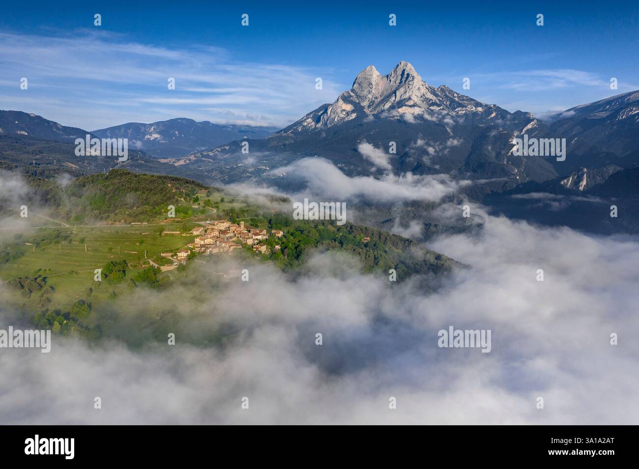 Aerial views of Pedraforca and the village of Maçaners over a sea of ...