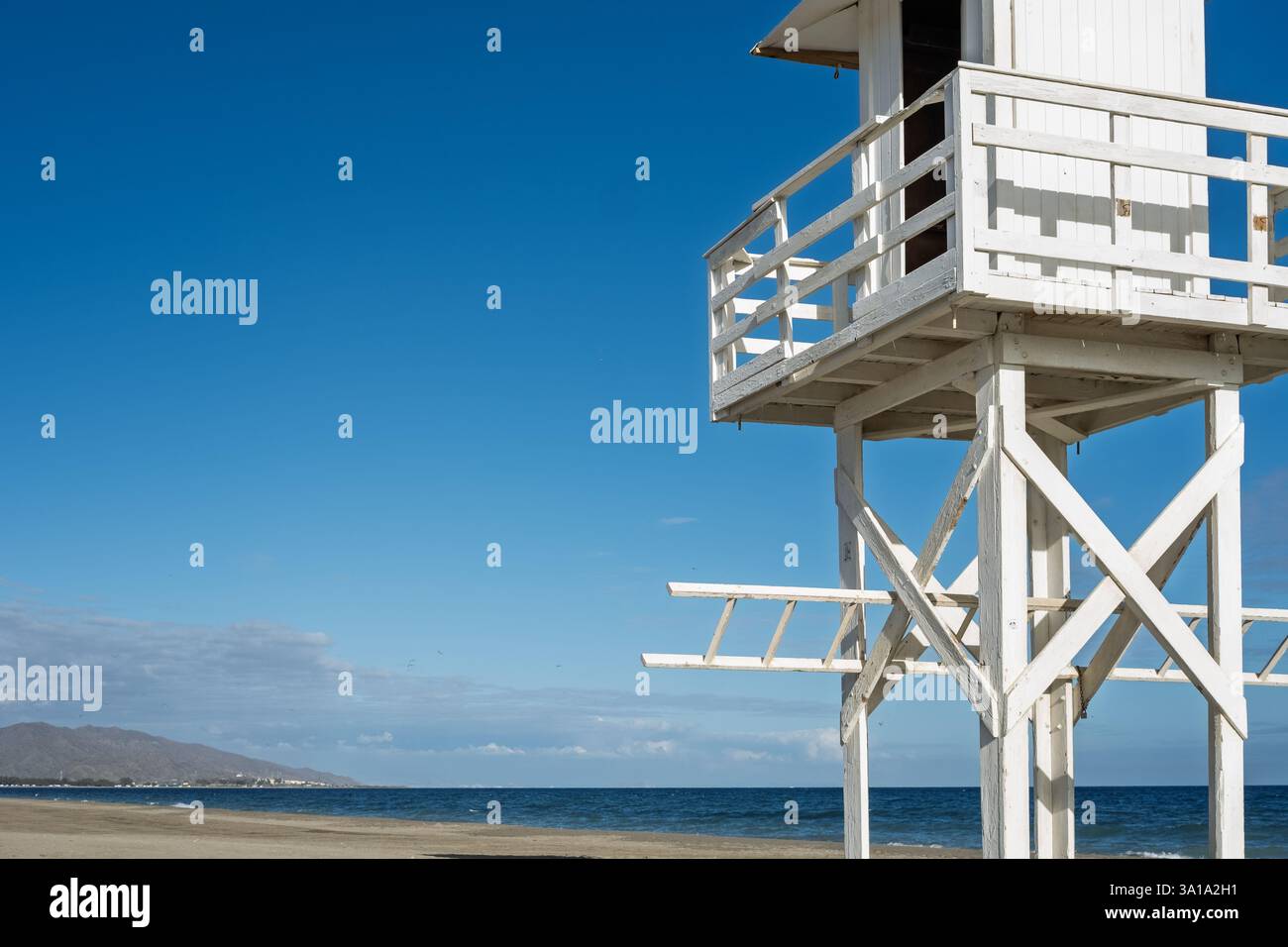 A lifeguard tower stands tall on Playa de Vera beach, with calm waves ...