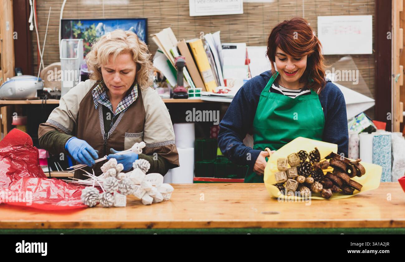 Two florists work in a nursery. Couple work in the gardening business ...