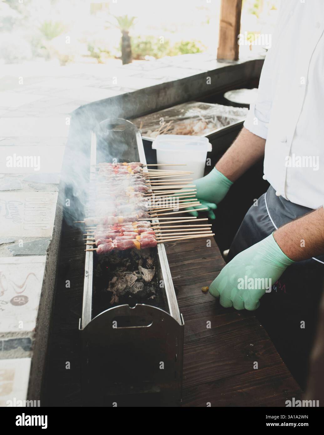 Man cooking the street food many skewers with lamb meat cooked grilled ...