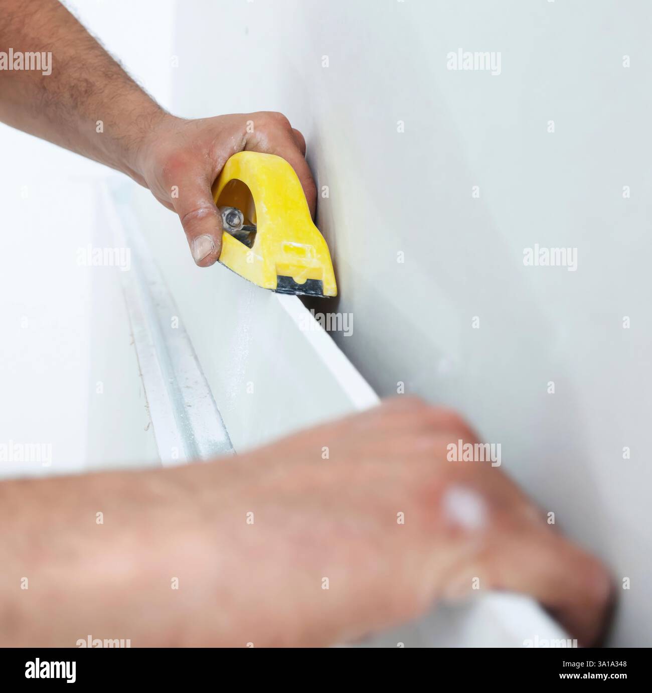 Construction worker is sanding drywall with sandpaper before painting ...