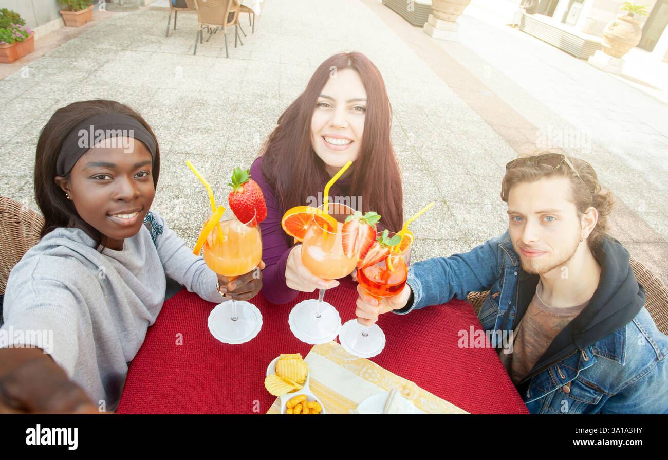 Three friends take a selfie make cheers celebrating multicultural ...