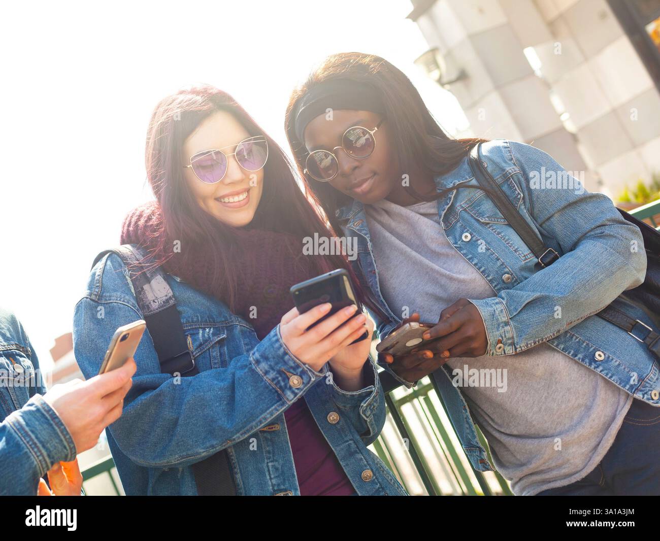 Multiracial friends having fun with smartphone in a spring day hi-res ...