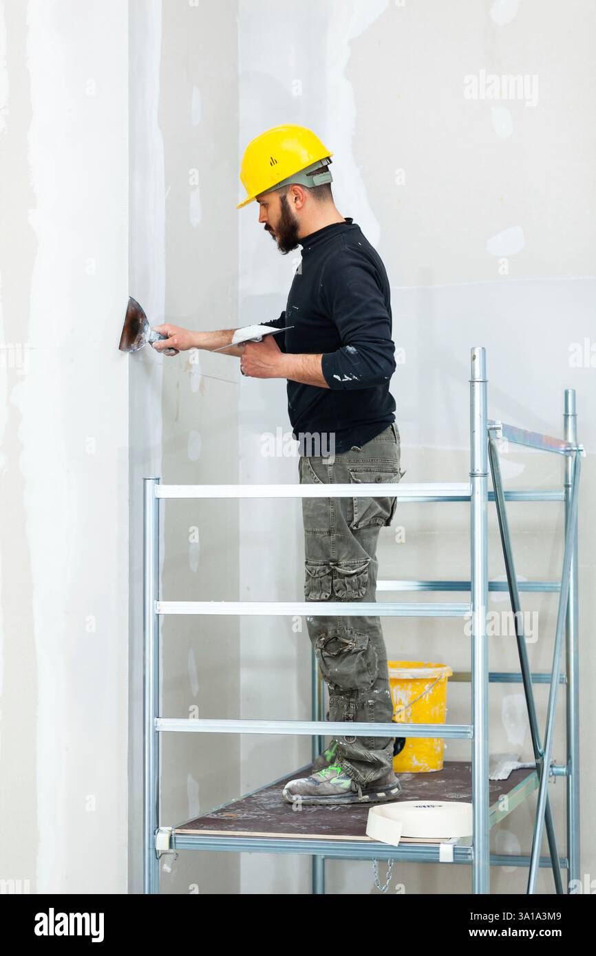 Interior construction, worker plastering gypsum board wall Stock Photo ...