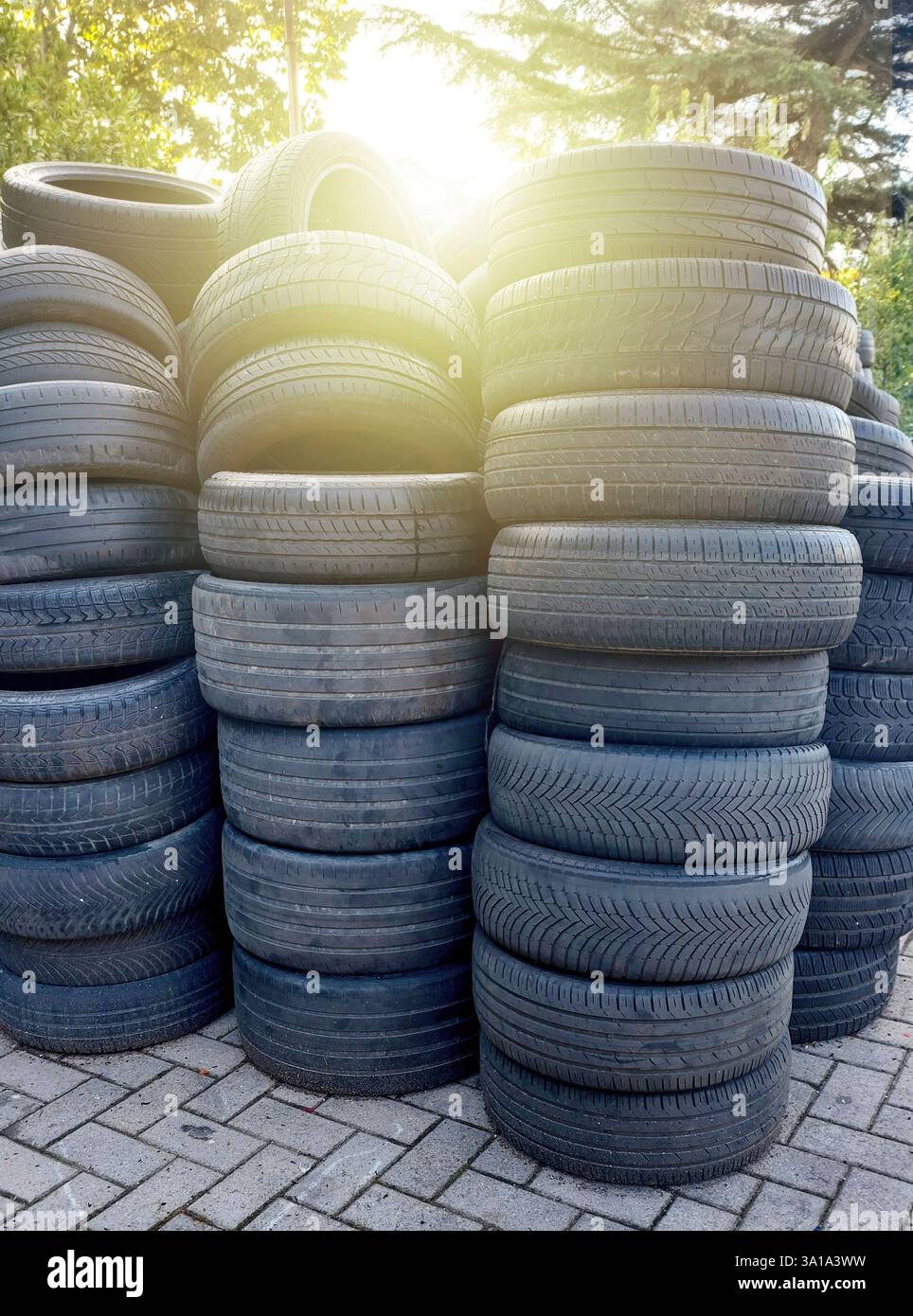 Large stack of old black car tires, showing intricate patterns and textures up close, highlights ...