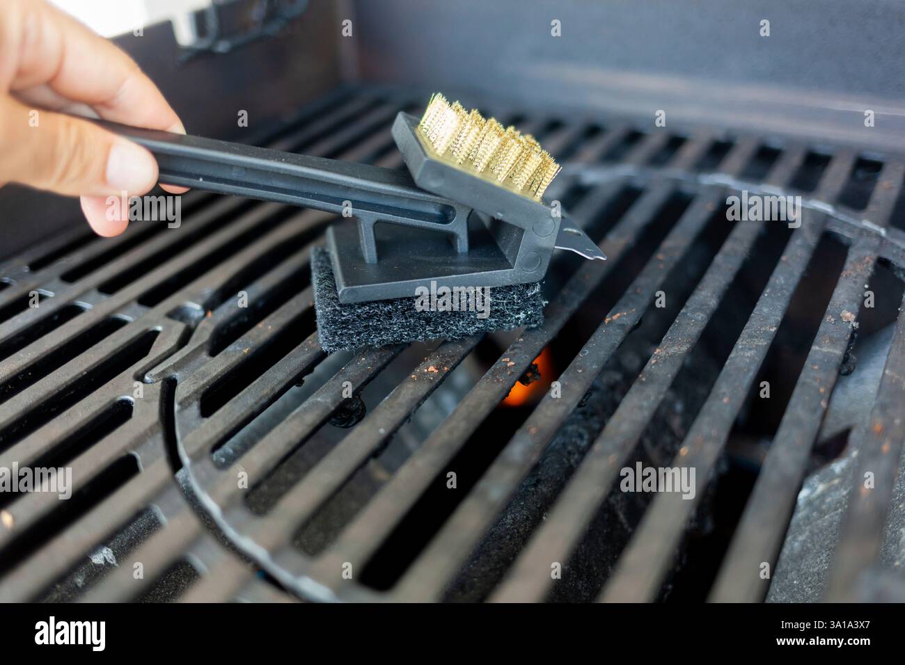 Person is cleaning a hot barbecue grill using a scraper brush Stock ...