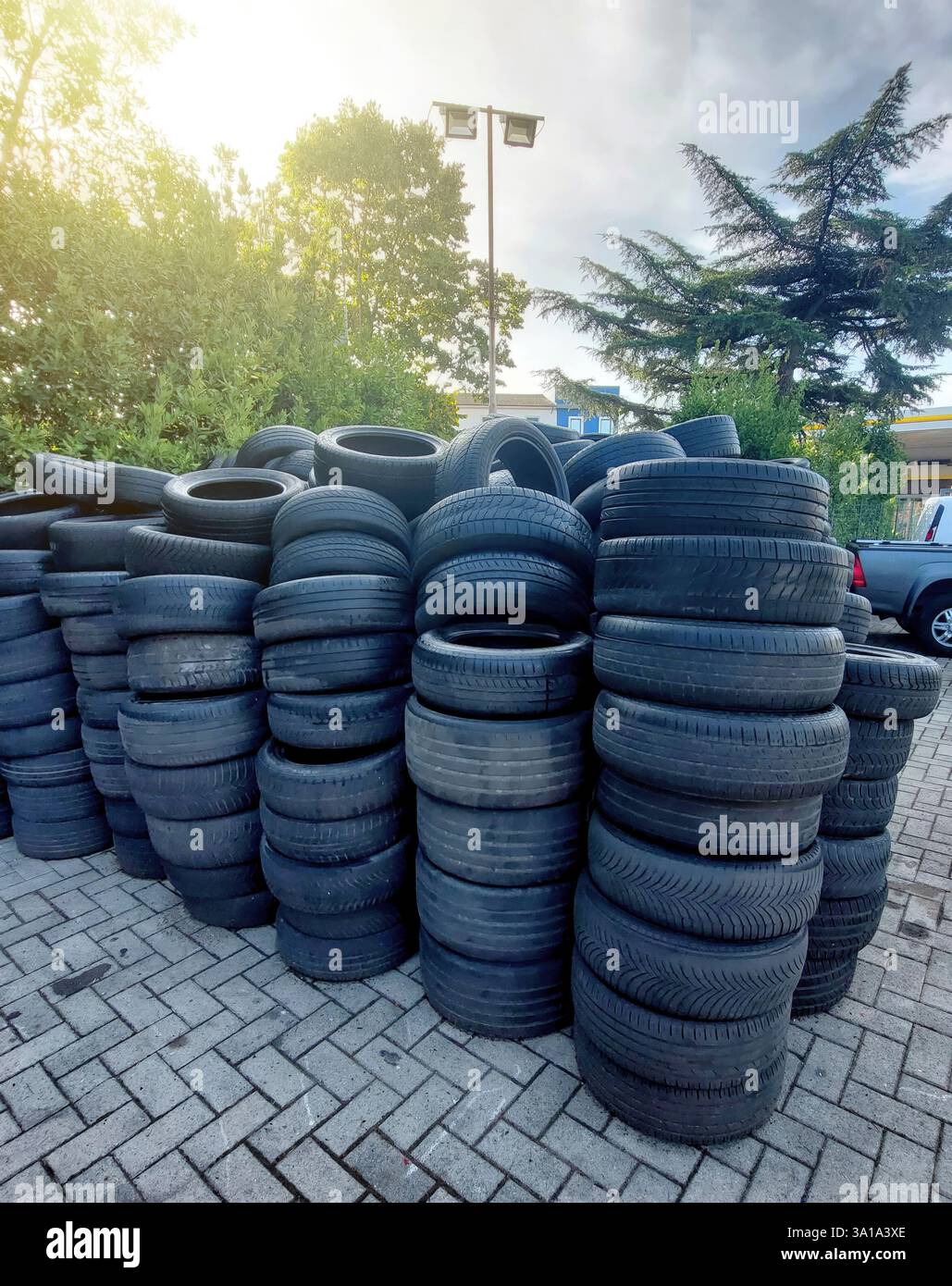 Many used car tires are stacked on top of each other, creating a large pile in an open air ...