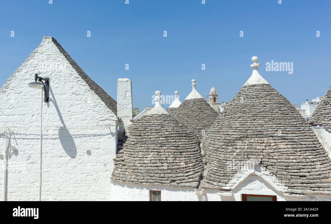 Cluster of traditional trulli houses with conical roofs forming a ...